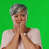 Green screen, bite nails and senior woman with scared, fear and worry ...