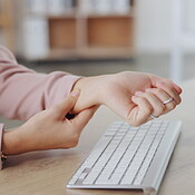 Hands, massage and woman with injury problem, carpal tunnel syndrome or ...