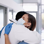Doctor, sad woman and crying with hug in support for grief, loss or ...