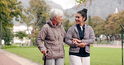Senior woman, walker and nurse talking in a park with healthcare for ...