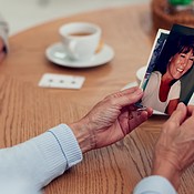 Family, memory and hand with a photo at tea for nostalgia, remember and ...