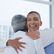 Nurse, doctor and happy woman hug in hospital for teamwork, celebration ...