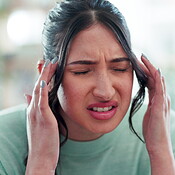 Face, woman and pain of headache in home from stress, mental health and ...
