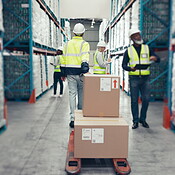 Boxes, trolley and warehouse person walking, transport product and ...