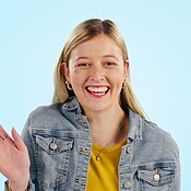 Face, wave hand and excited woman in studio isolated on blue background ...