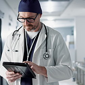 Surgeon, doctor and tablet for hospital, healthcare or clinic research ...