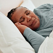 Senior woman, bed and sleeping in bedroom, tired and alone for rest ...