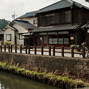 Japan, architecture and canal by houses in countryside with trees and ...