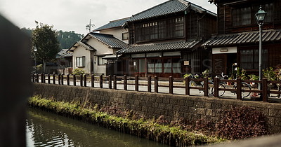 Japan, architecture and canal by houses in countryside with trees and ...