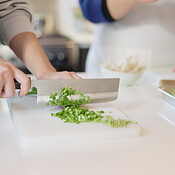 Japanese, cooking and hands of woman with vegetables in home chop with ...