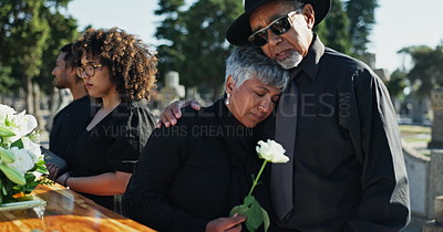 Funeral, man and woman hug at graveyard for memorial service at burial ...