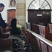 Senior woman, flowers and funeral at chapel with wheelchair, man and ...