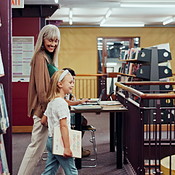 Library, librarian and kid on smile for books, growth and development ...