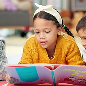 Children, kindergarten and reading book in classroom, childhood ...