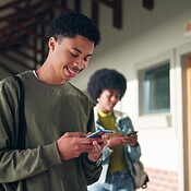 Boy, texting and happy on smartphone in high school, communication and ...