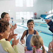 Cheering, children in huddle and swimming instructor woman in gymnasium ...