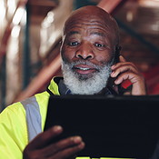 Phone call, factory and black man on tablet for shipping, supply chain ...