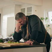 Chef, pain and man in kitchen, headache and thinking with burnout in ...