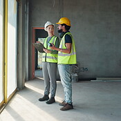 Architect, people and discussion with clipboard for construction, site ...