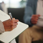 Psychologist, notebook and hands writing for listening, counseling and ...