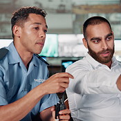 Security, pointing and men at computer in control room for defence ...