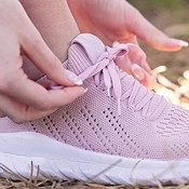 Hands, tie shoelace and woman with fitness, outdoor and sneakers with sports, workout and nature ...