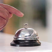 Hand, desk and person with bell in hotel for help, concierge and ...