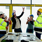 Construction, team and celebration with blueprint, teamwork and ...