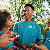 Phone, volunteer and group of people in park for charity event ...