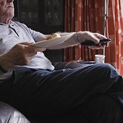 Watching tv, eating and senior man on sofa enjoying freedom, retirement ...