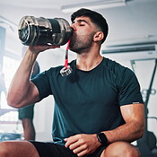 Athlete, man and drink water in gym for fitness, hydration and thirsty ...