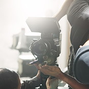 Film, setup and men with camera on set for shooting, check lighting and ...