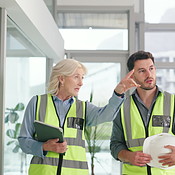 Building, civil engineer and people with tablet, talking and discussion ...